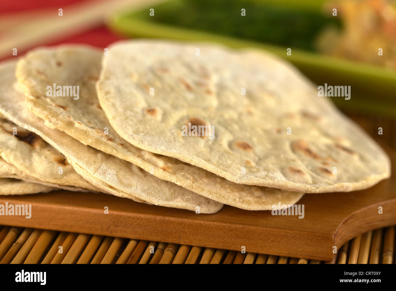 Fresh homemade Indian flatbread called chapati on wooden board ...