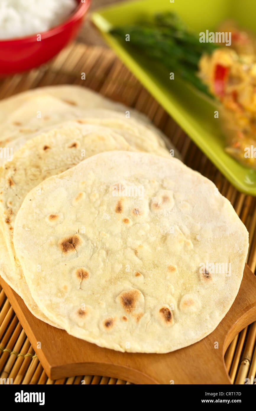 Fresh homemade Indian flatbread called chapati on wooden board ...