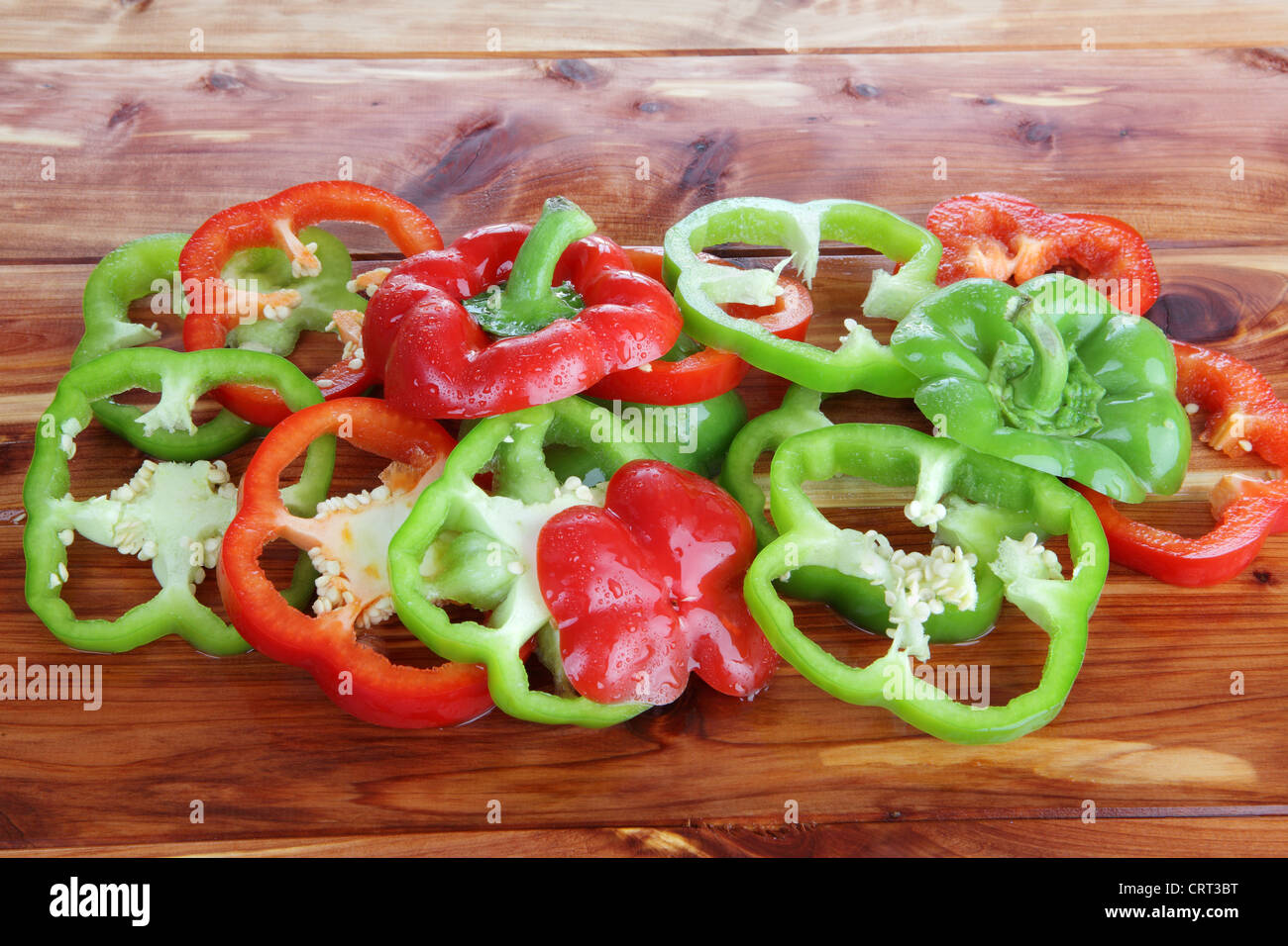 Freshly sliced organic washed green and red bell peppers in a rustic ...