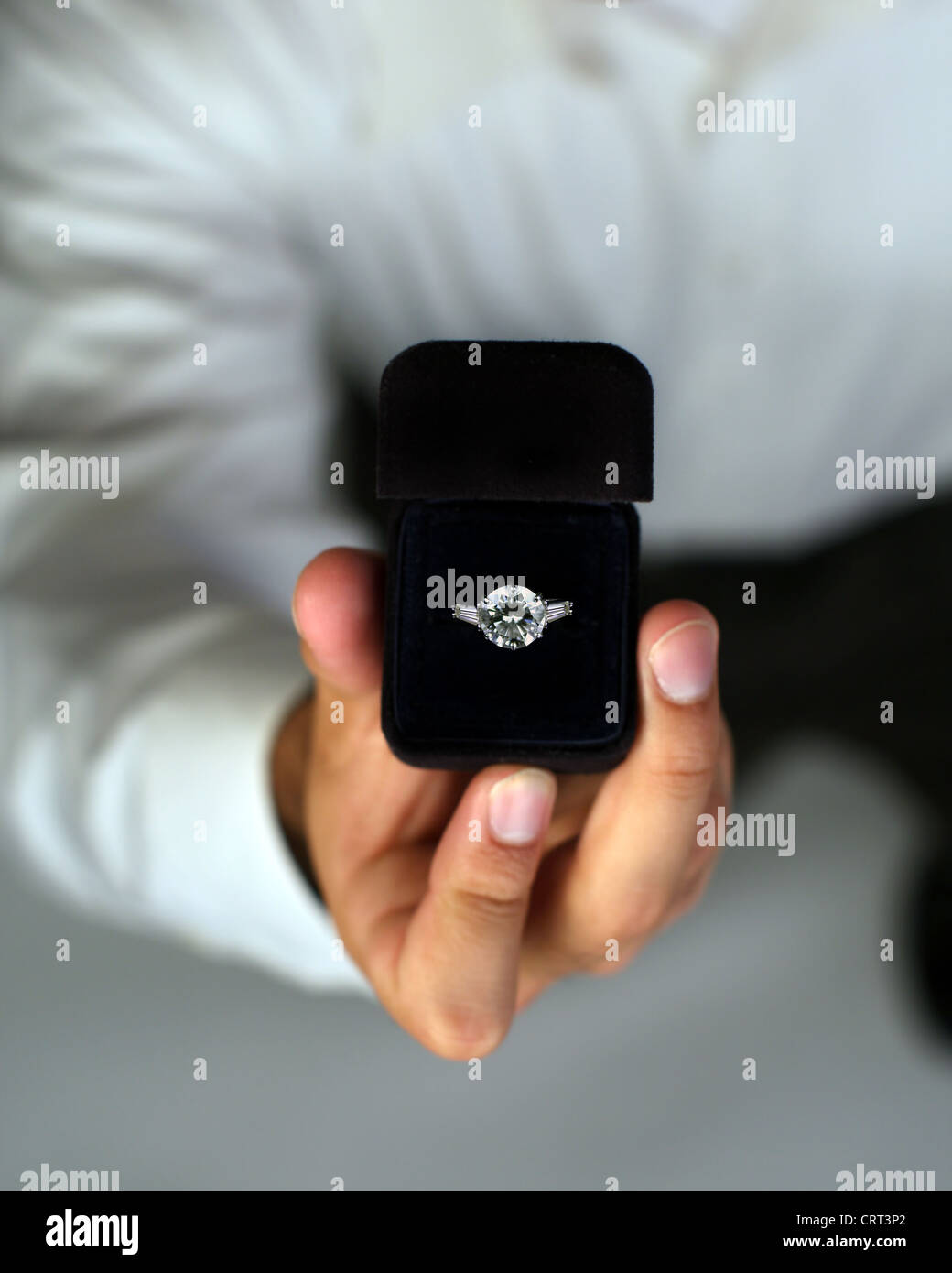 A man proposing and holding up an engagement ring Stock Photo - Alamy