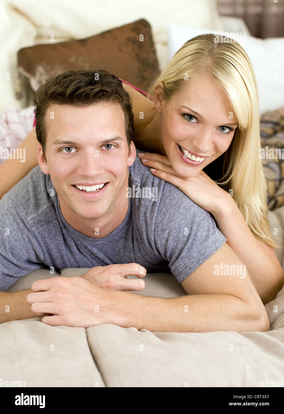 Happy couple relaxing in bed Stock Photo - Alamy