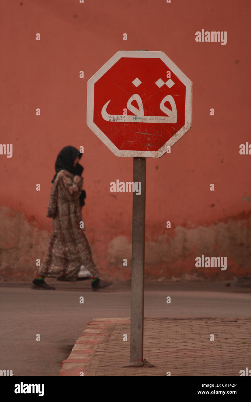 an Arabic stop sign with a Moroccan woman in the back Stock Photo - Alamy