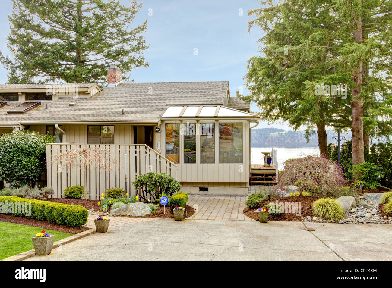 Simple one story American house with water view and spring landscape ...