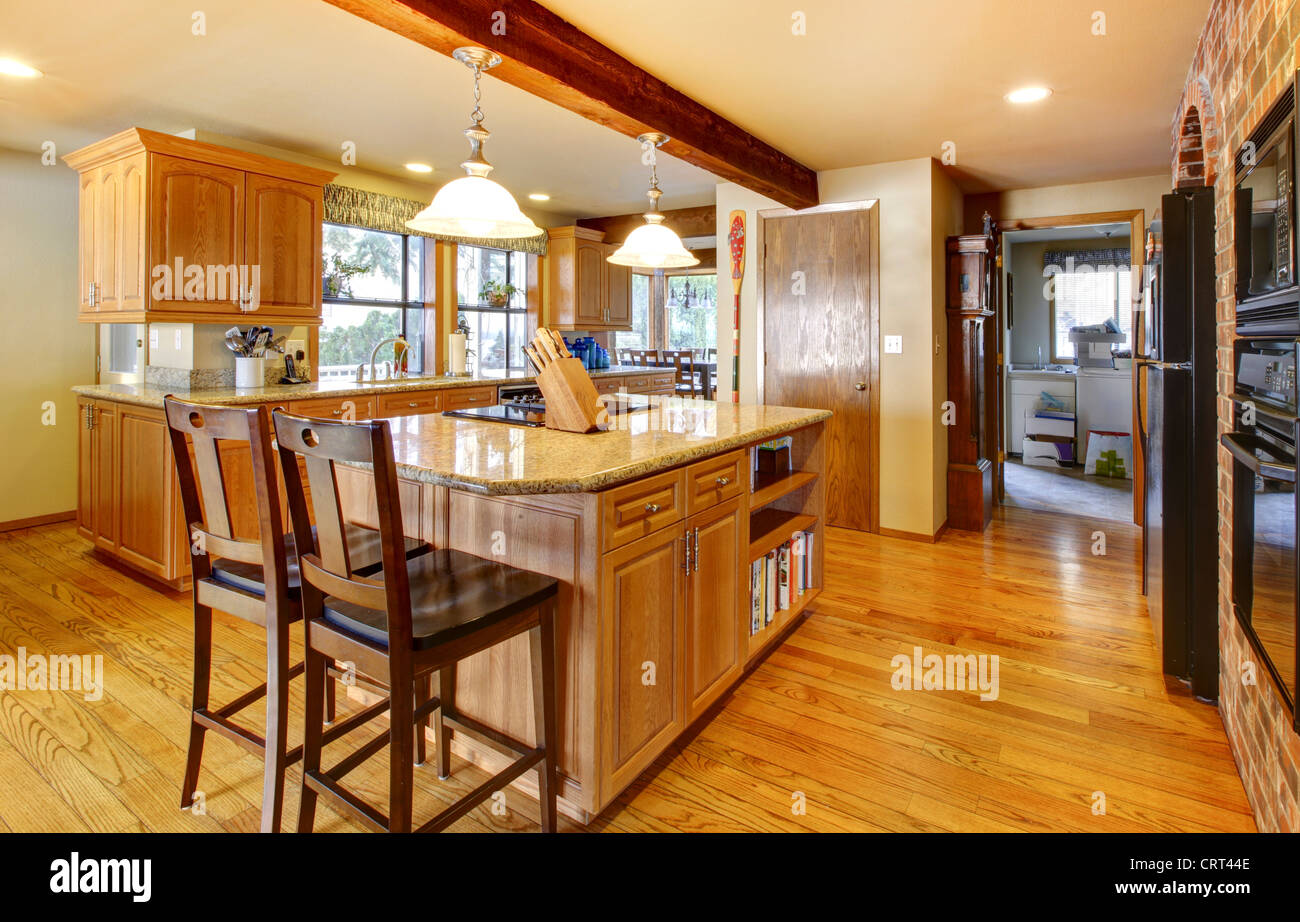 Golden warm wood kitchen with large island and back appliances Stock ...