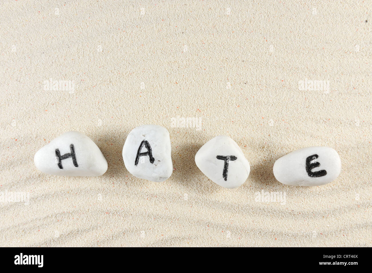 Hate word on group of stones with sand background Stock Photo - Alamy