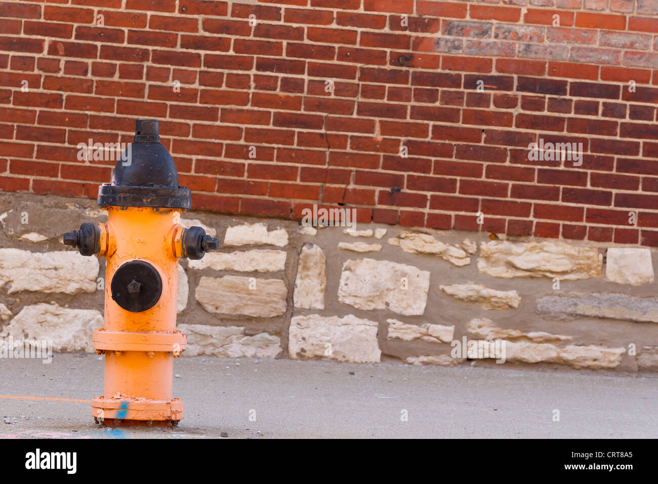 Typical fire hydrant against a brick wall on a city street Stock Photo ...