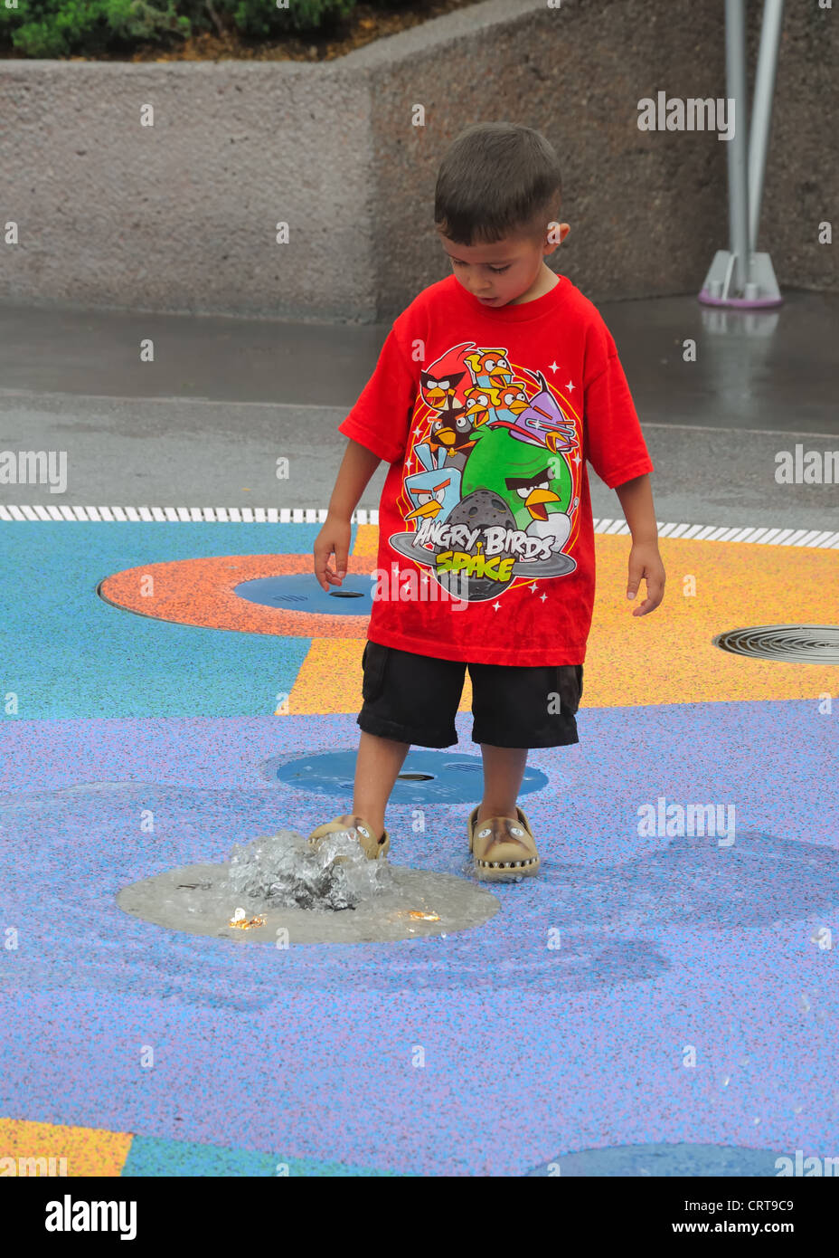 A young boy plays with a water jet at a theme park in Orlando, Florida ...