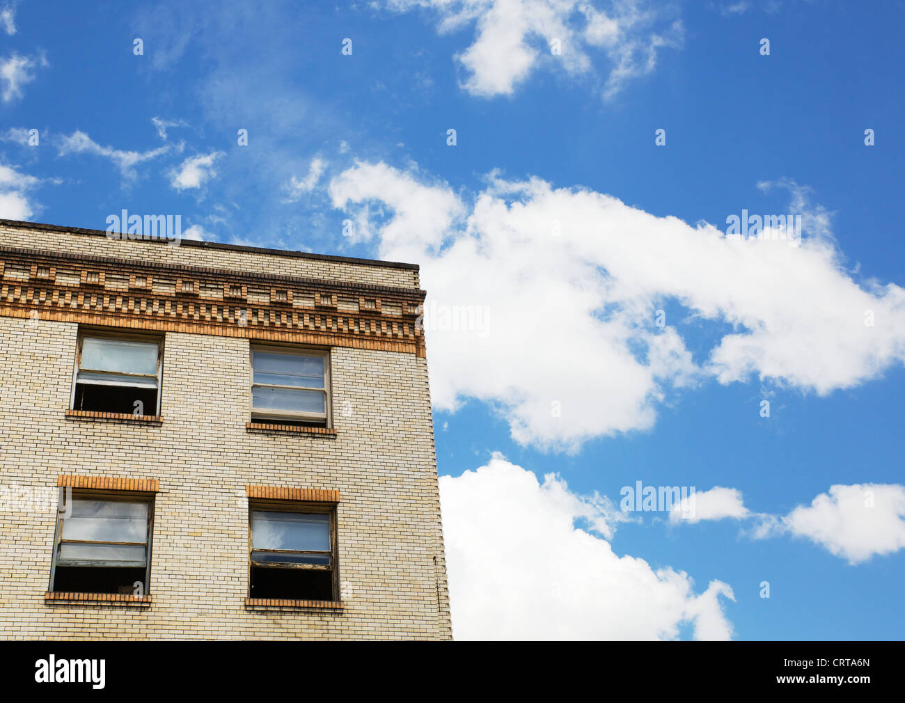 Old Tan brick building with four window against a brilliant blue sky ...