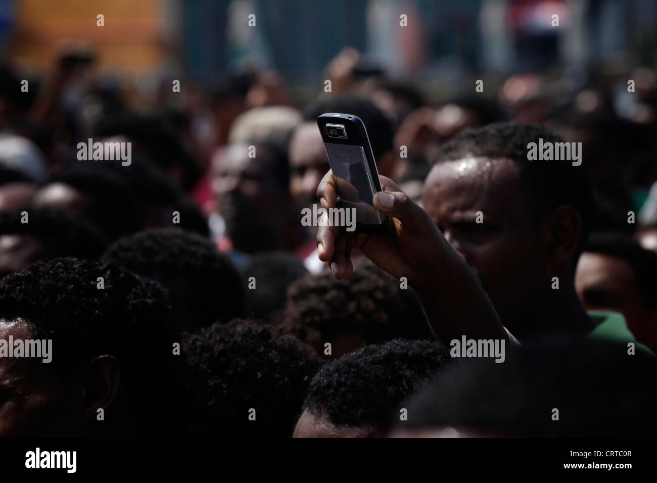 A man using his cellular phone to photograph a demonstration in Eritrea ...