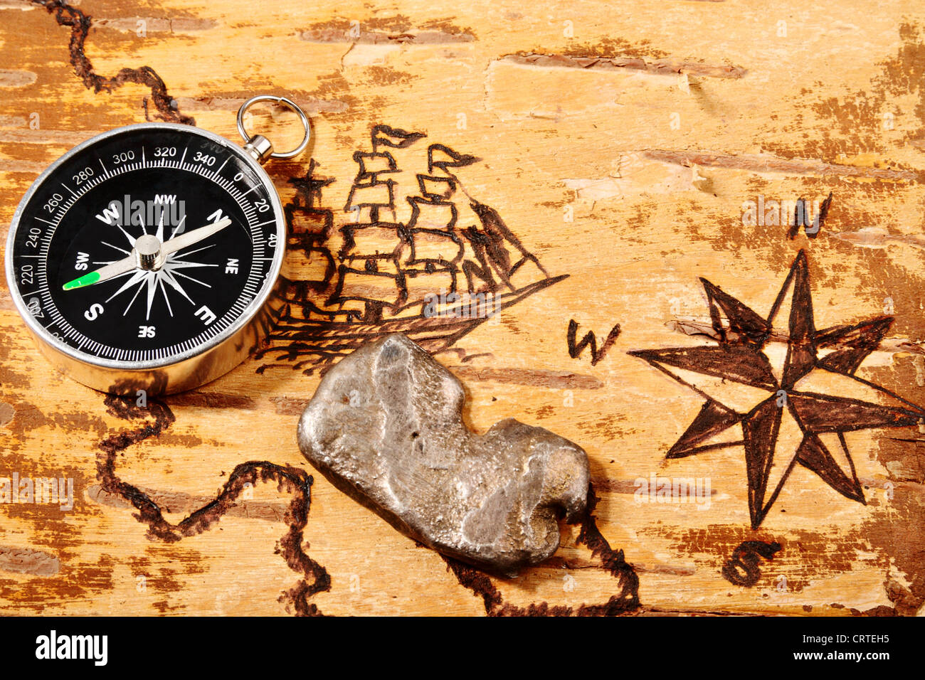 Compass and ingot of silver on marine chart on the order of olden time ...