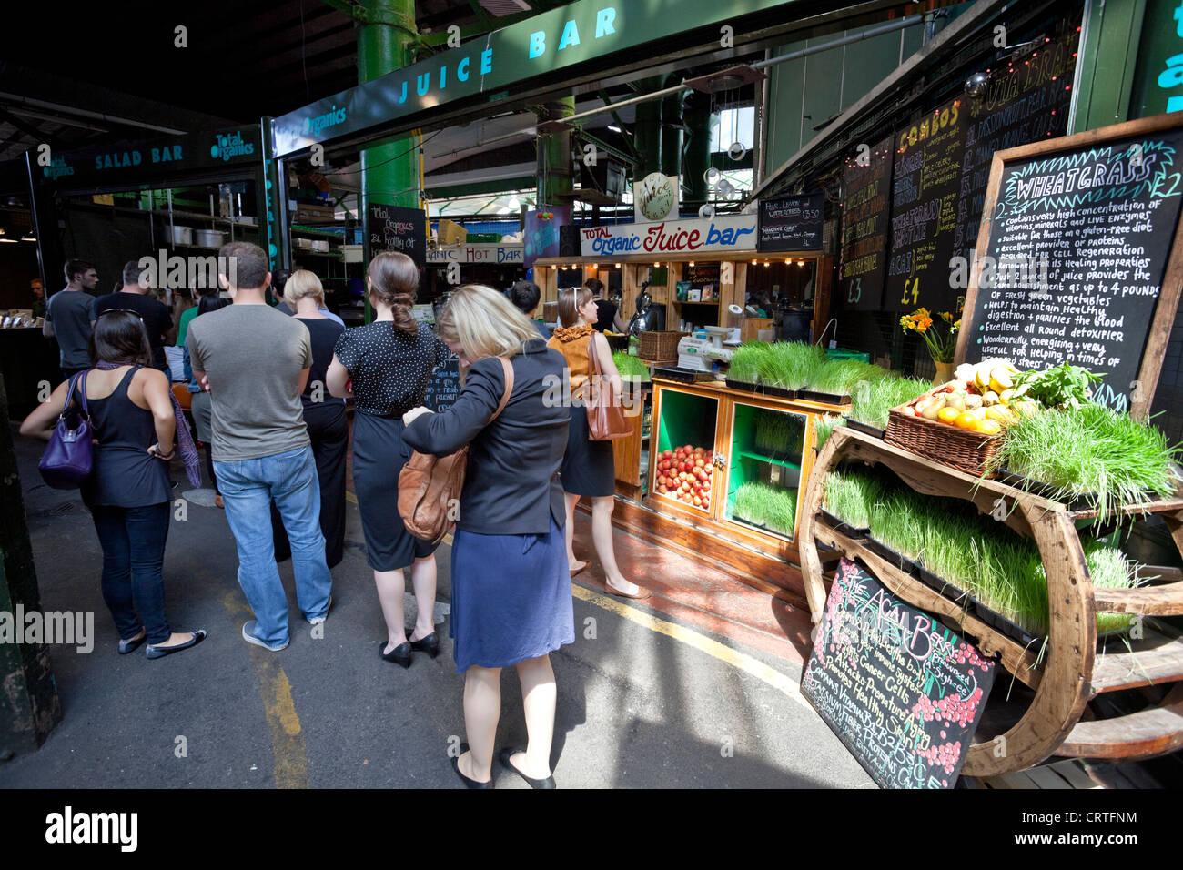 A group of people waiting in line at a juice bar, Borough Market ...