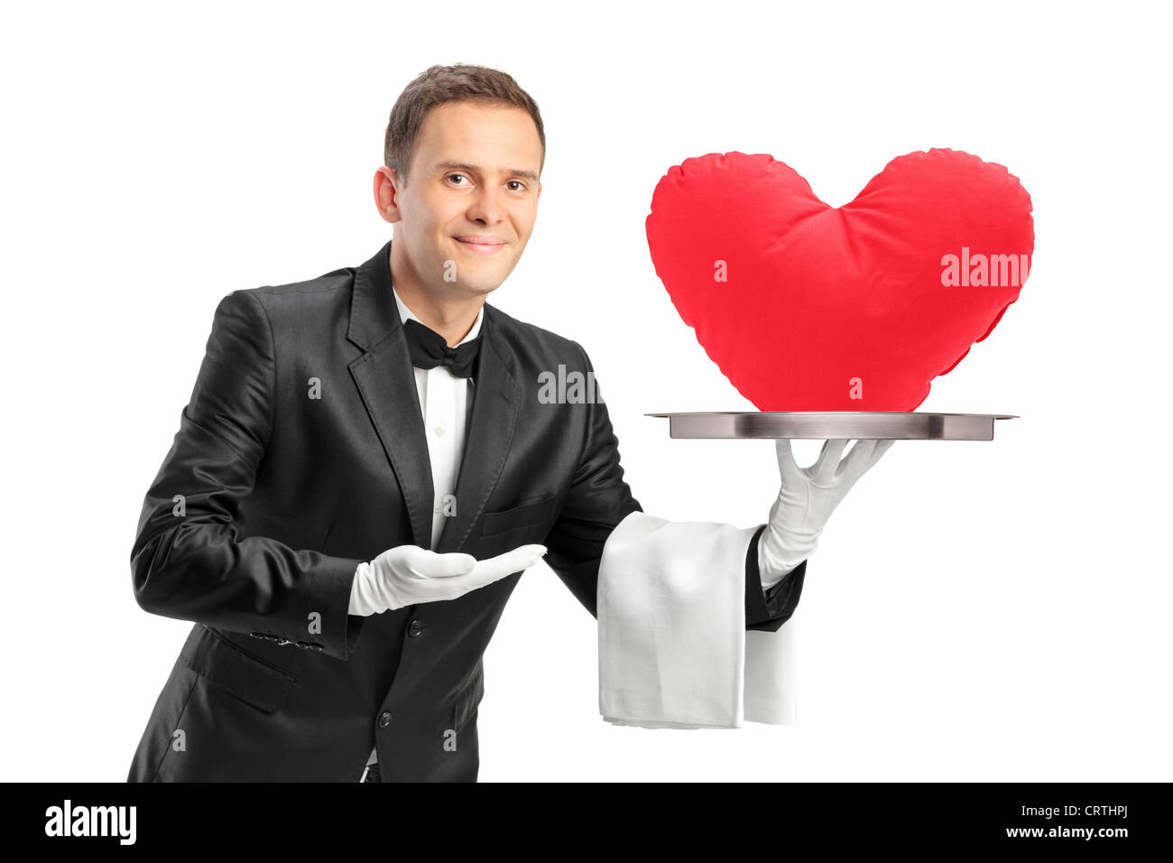 A butler holding a tray with a red heart shape object on it isolated on ...