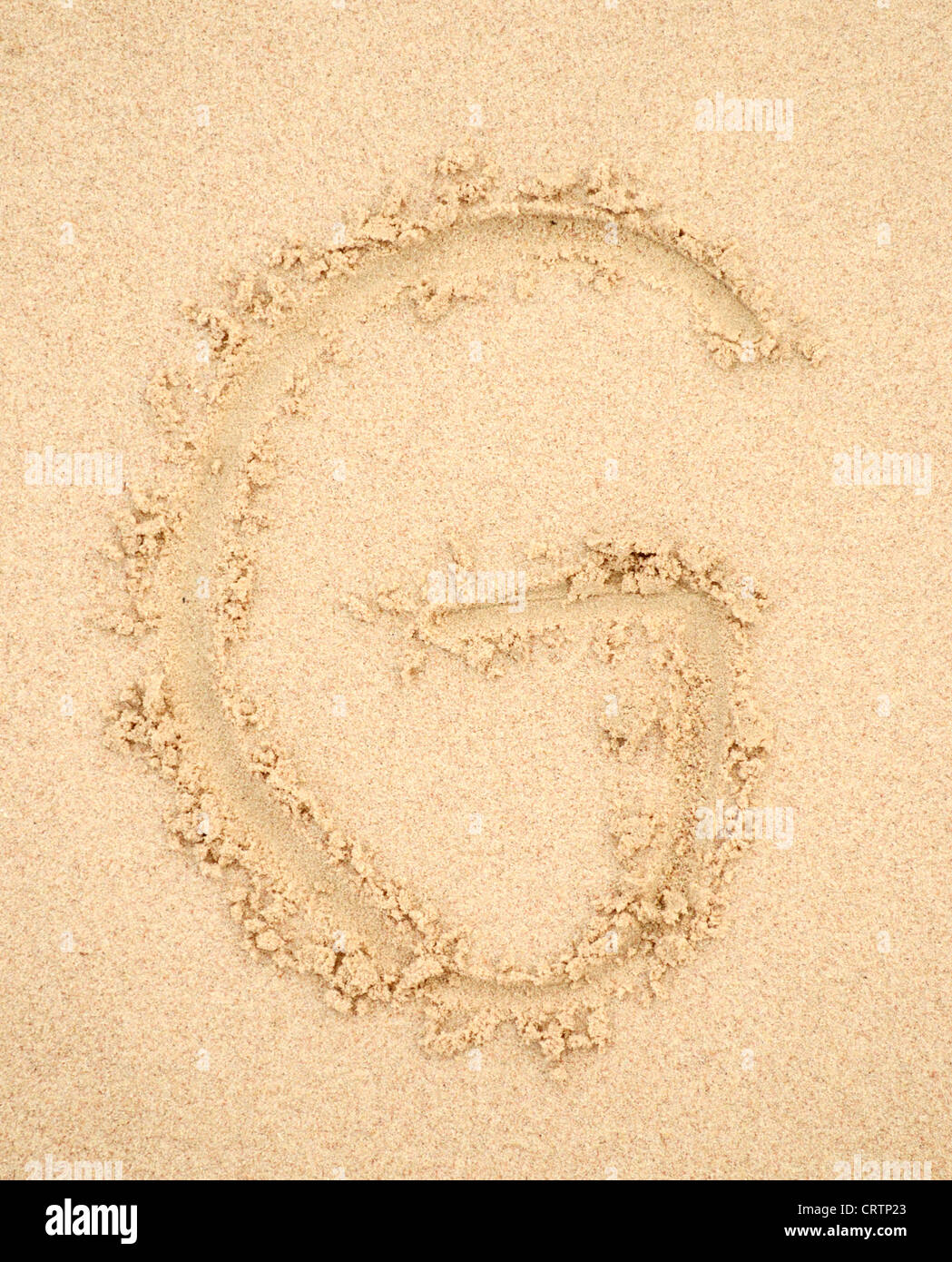 g letter written in the sand Stock Photo - Alamy