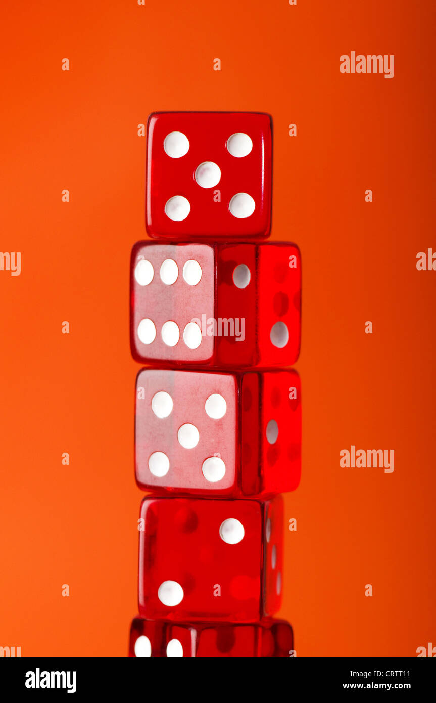 Red dice stack against orange background Stock Photo - Alamy