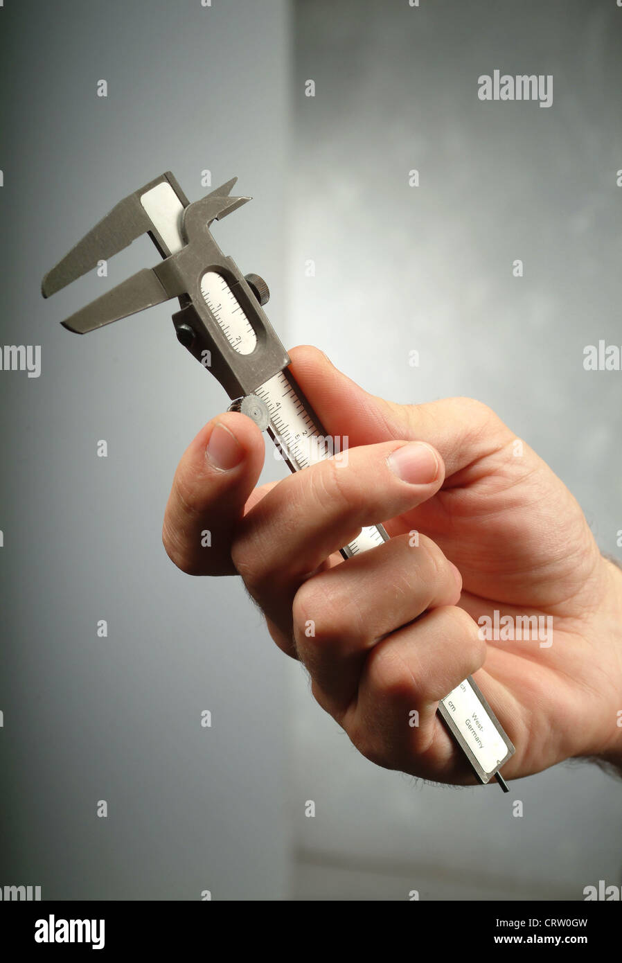 Hand with caliper Stock Photo - Alamy