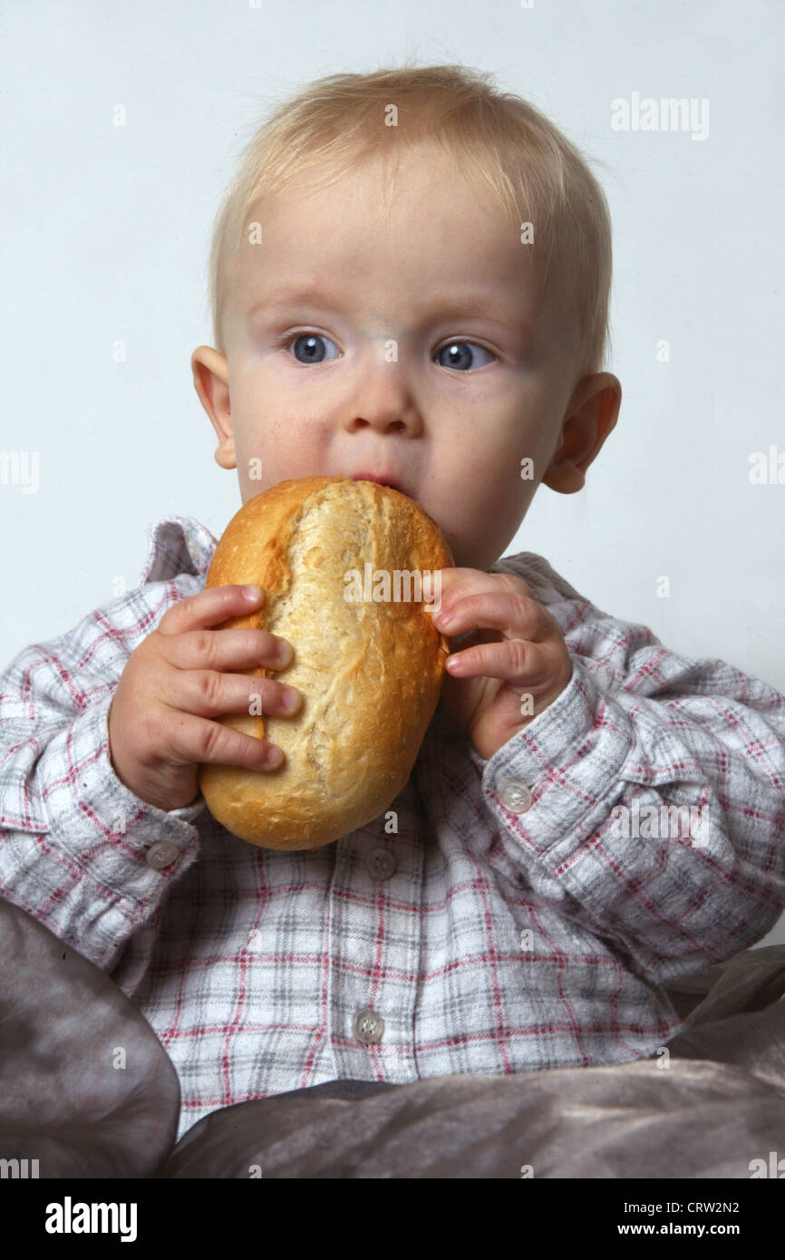 A small child while eating a buns Stock Photo - Alamy