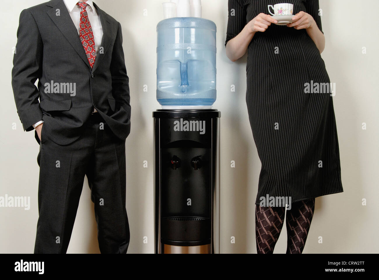 Two people standing at the watercooler Stock Photo - Alamy