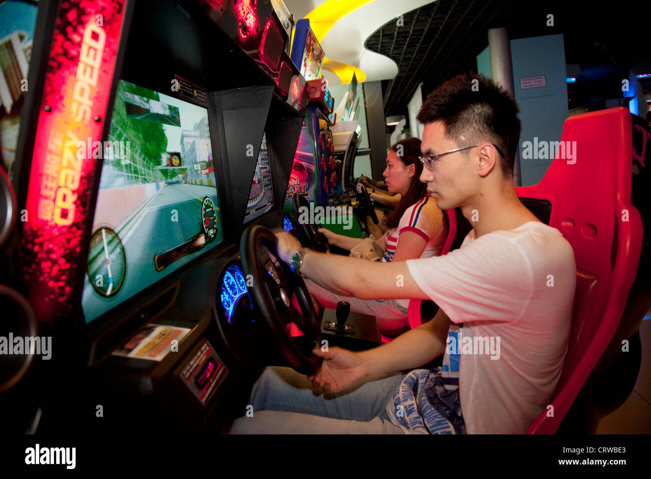 Young Chinese people playing computer games in an amusement arcade in ...