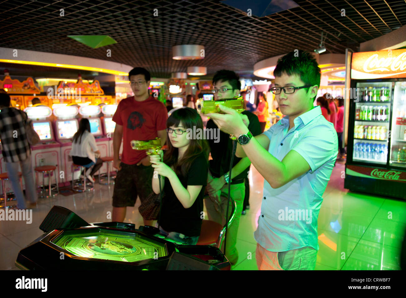 Young Chinese people playing a shooting computer game in an amusement ...