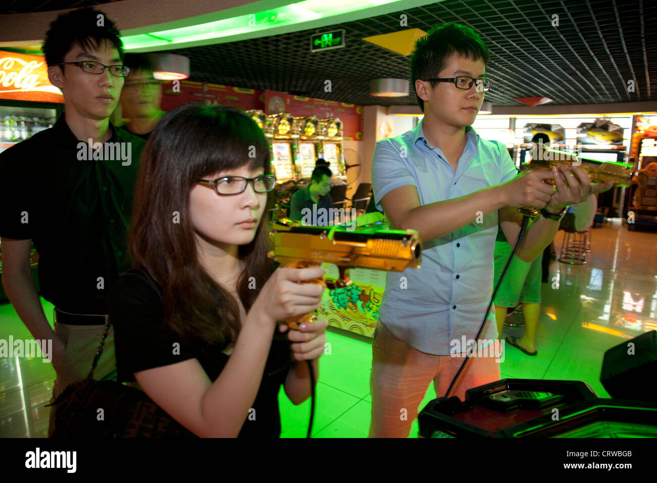 Young Chinese people playing a shooting computer game in an amusement ...