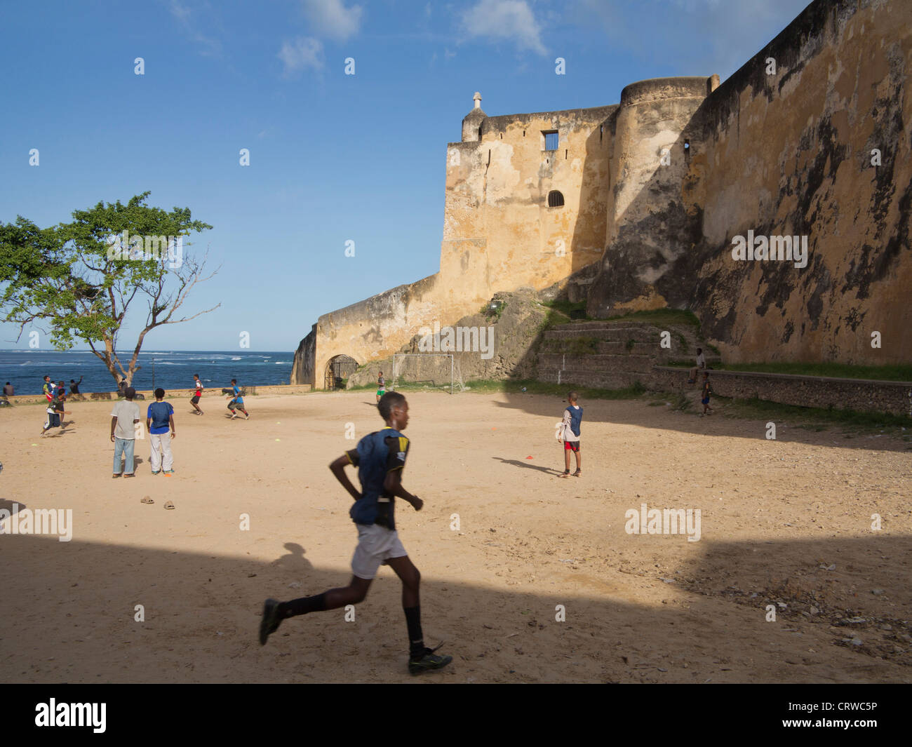 Youth play football outside Fort Jesus in the old town in Mombasa ...