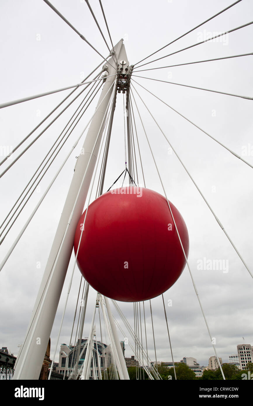The Red Ball Project hanging on the Golden Jubilee Bridge, London Stock ...
