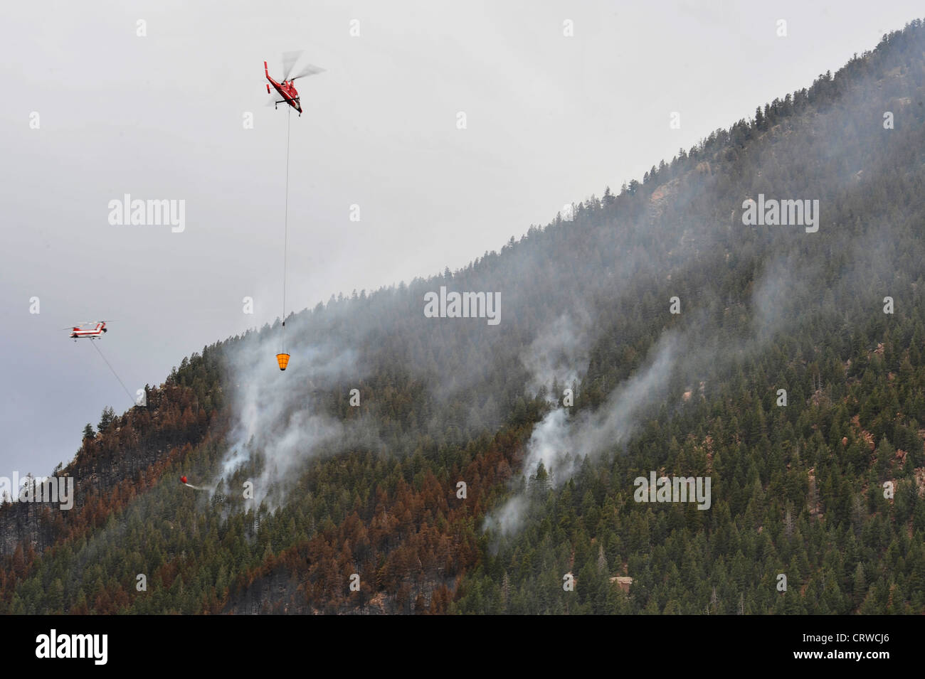A helicopter dumps water on the Waldo Canyon Fire that has spread to ...