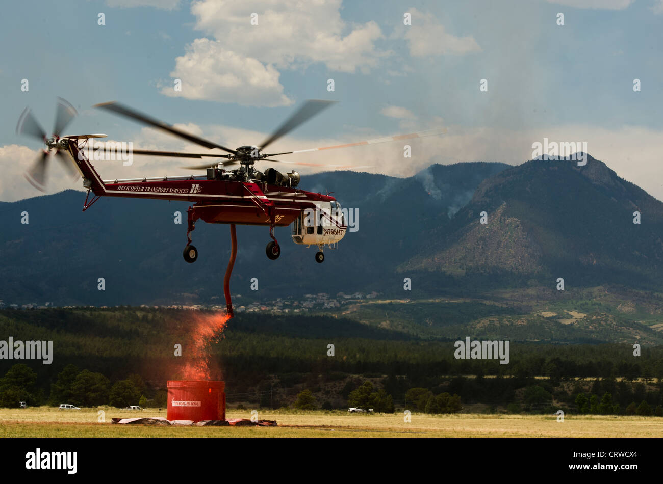 A helicopter contracted by the U.S. Forest Service drops retardant in ...