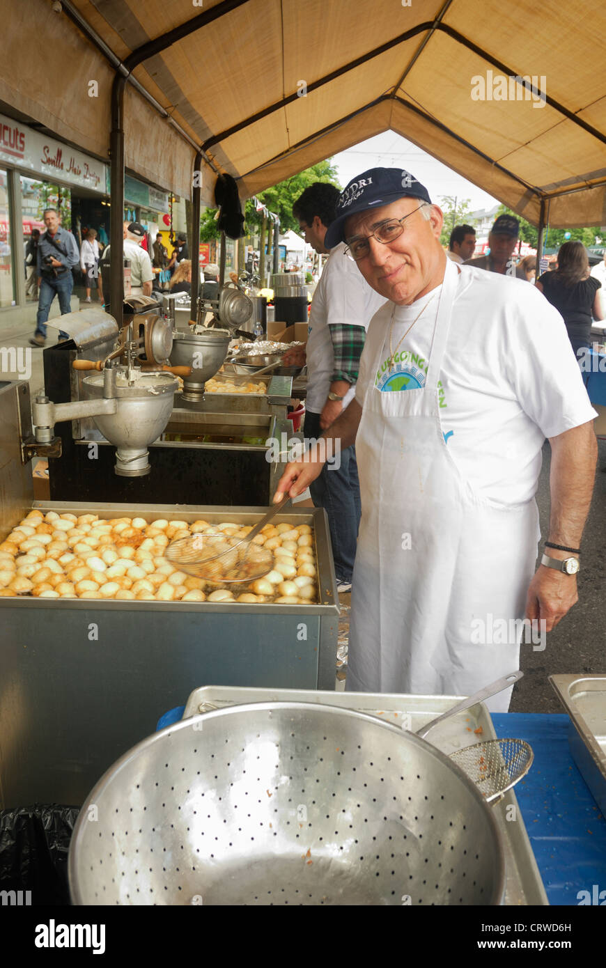 Greek man deep frying loukoumades during the popular Greek Day festival ...