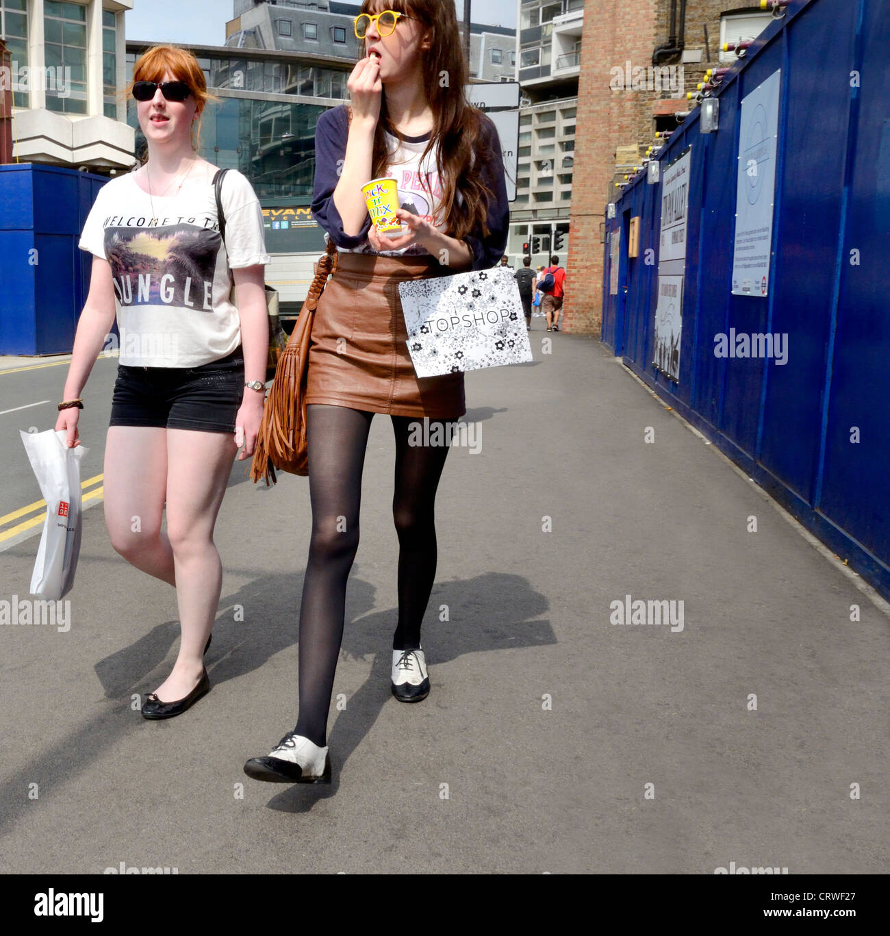 London, England, UK. Two girls with shopping, one eating pick 'n' mix ...