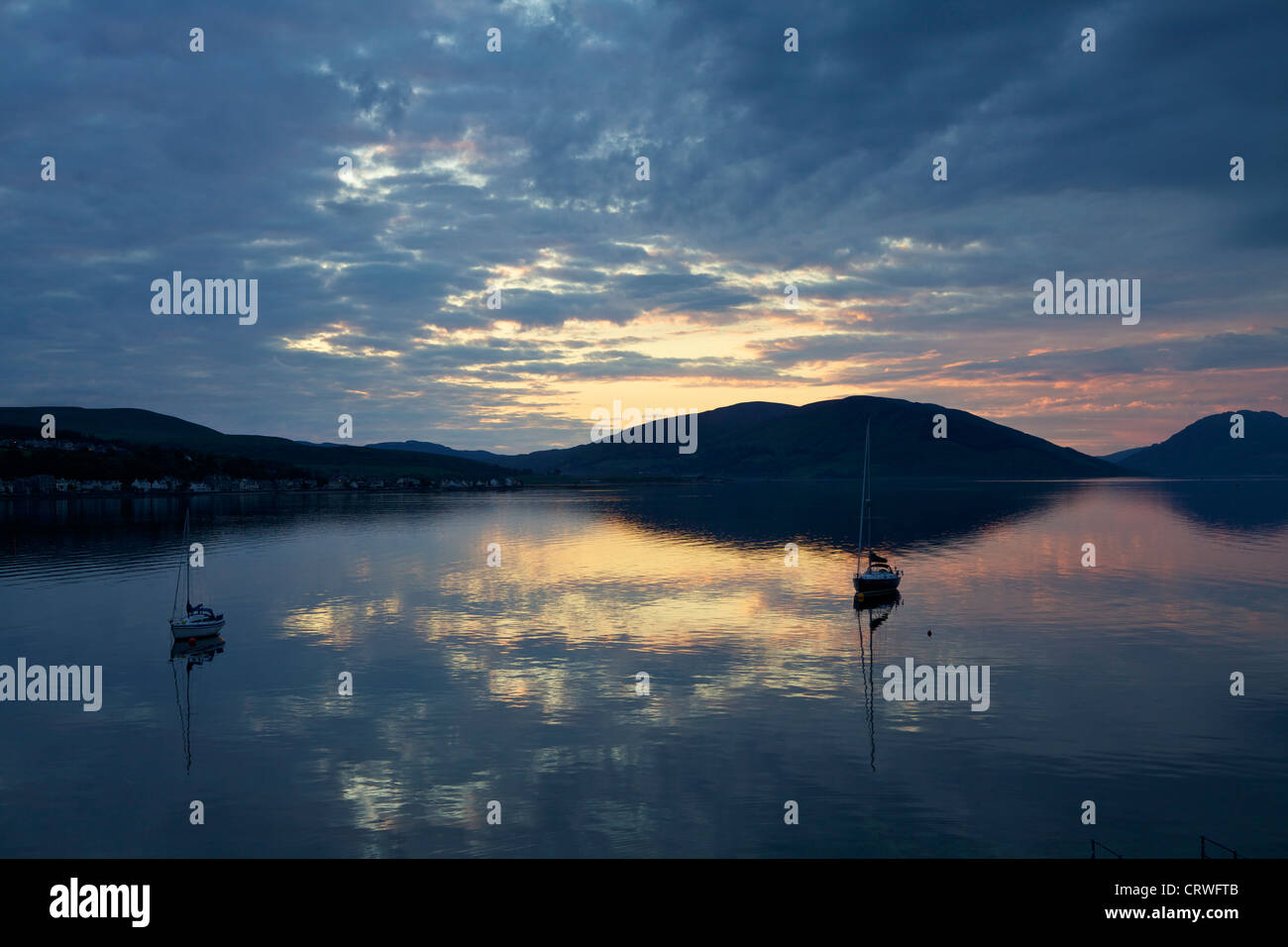 Rothesay bay at sunset with a yacht moored up and Loch Striven in Cowal ...