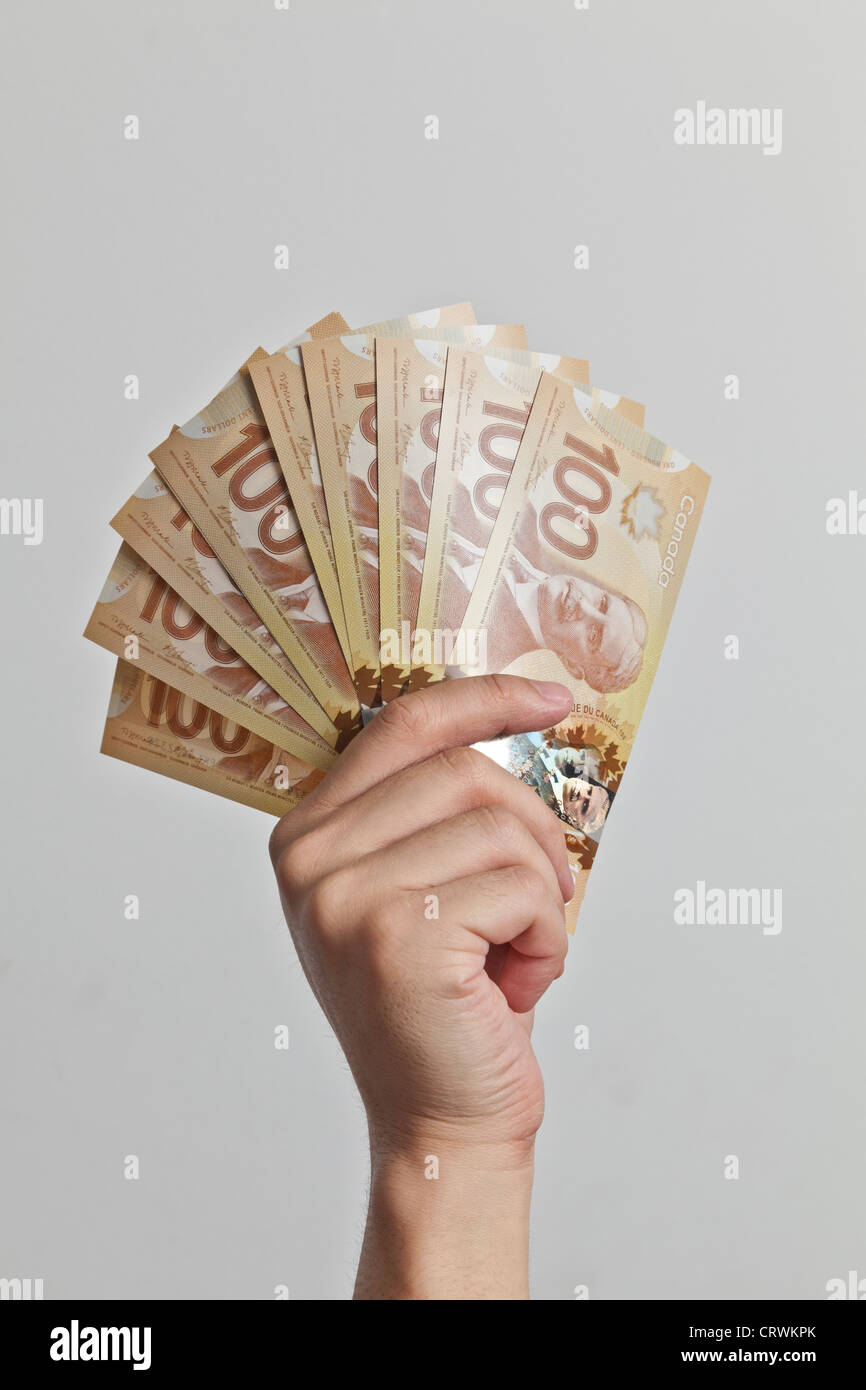 Man holding new Canadian $100 bills made from plastic polymer designed ...