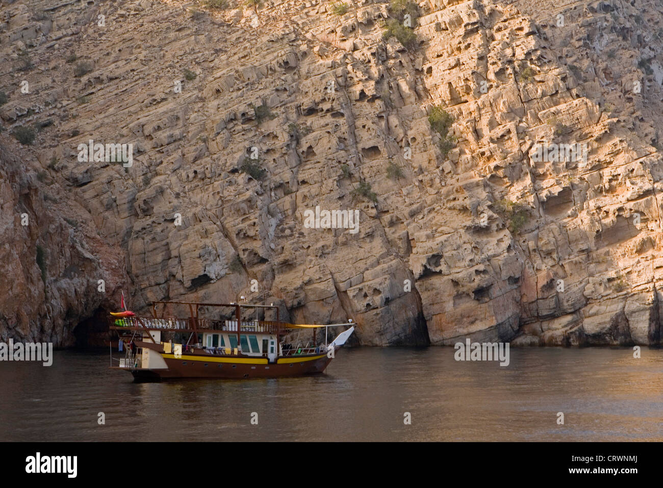 Dhow anchors beneath jagged peaks, Limah Bay, Limah, Musandam (east ...