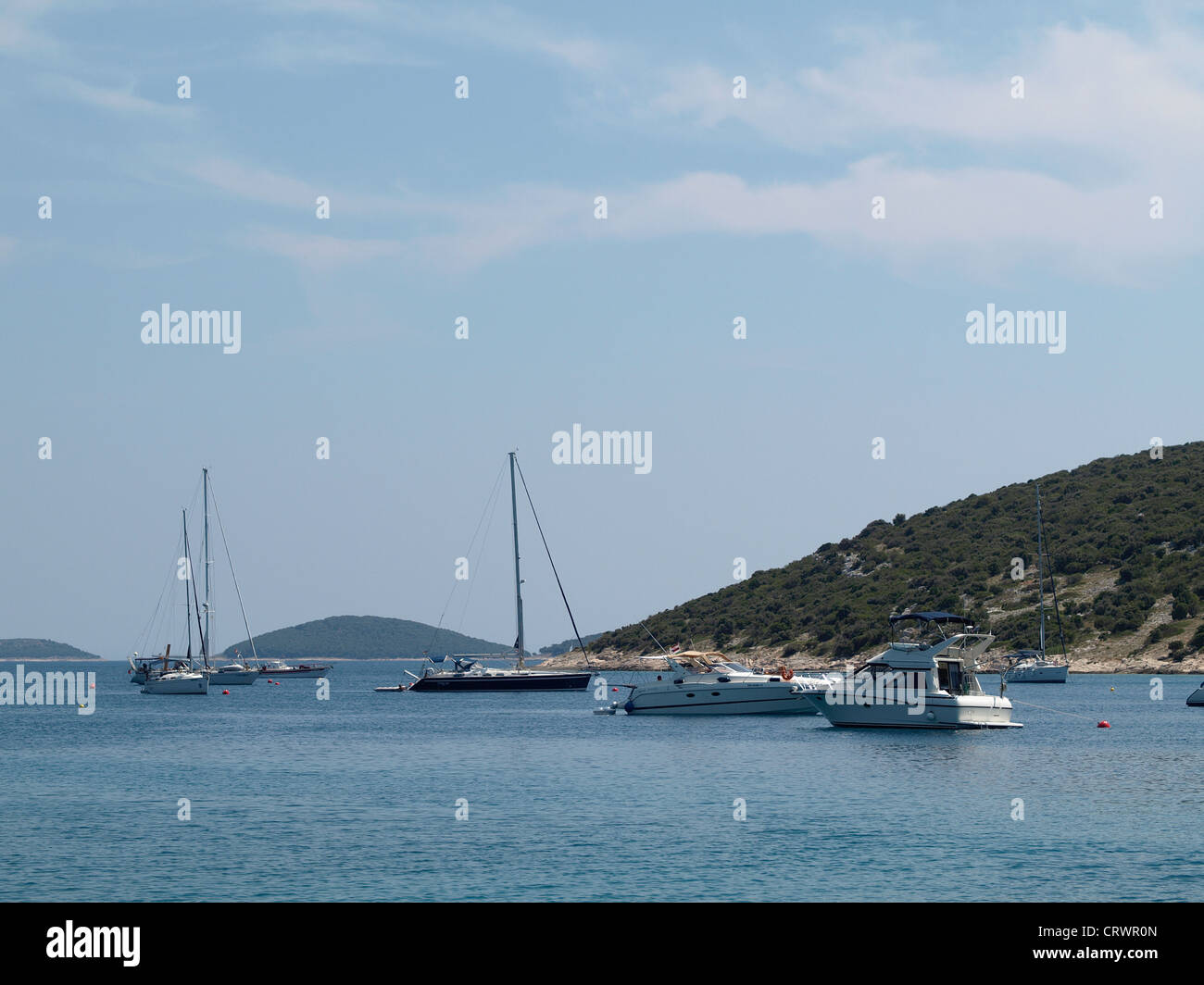A little sea bay with sailing boats and islands in distance Stock Photo ...