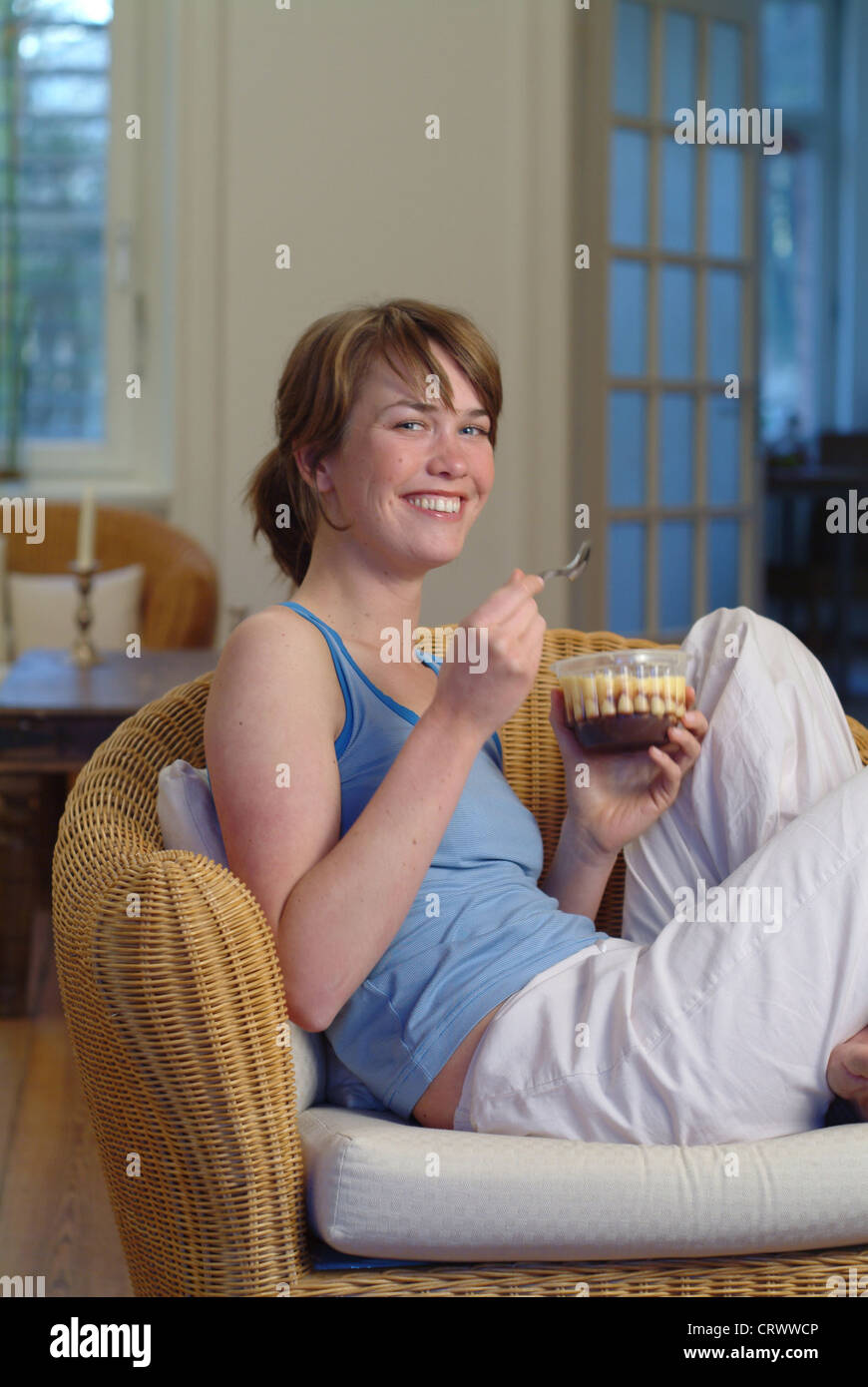 Young woman eating a pudding Stock Photo - Alamy