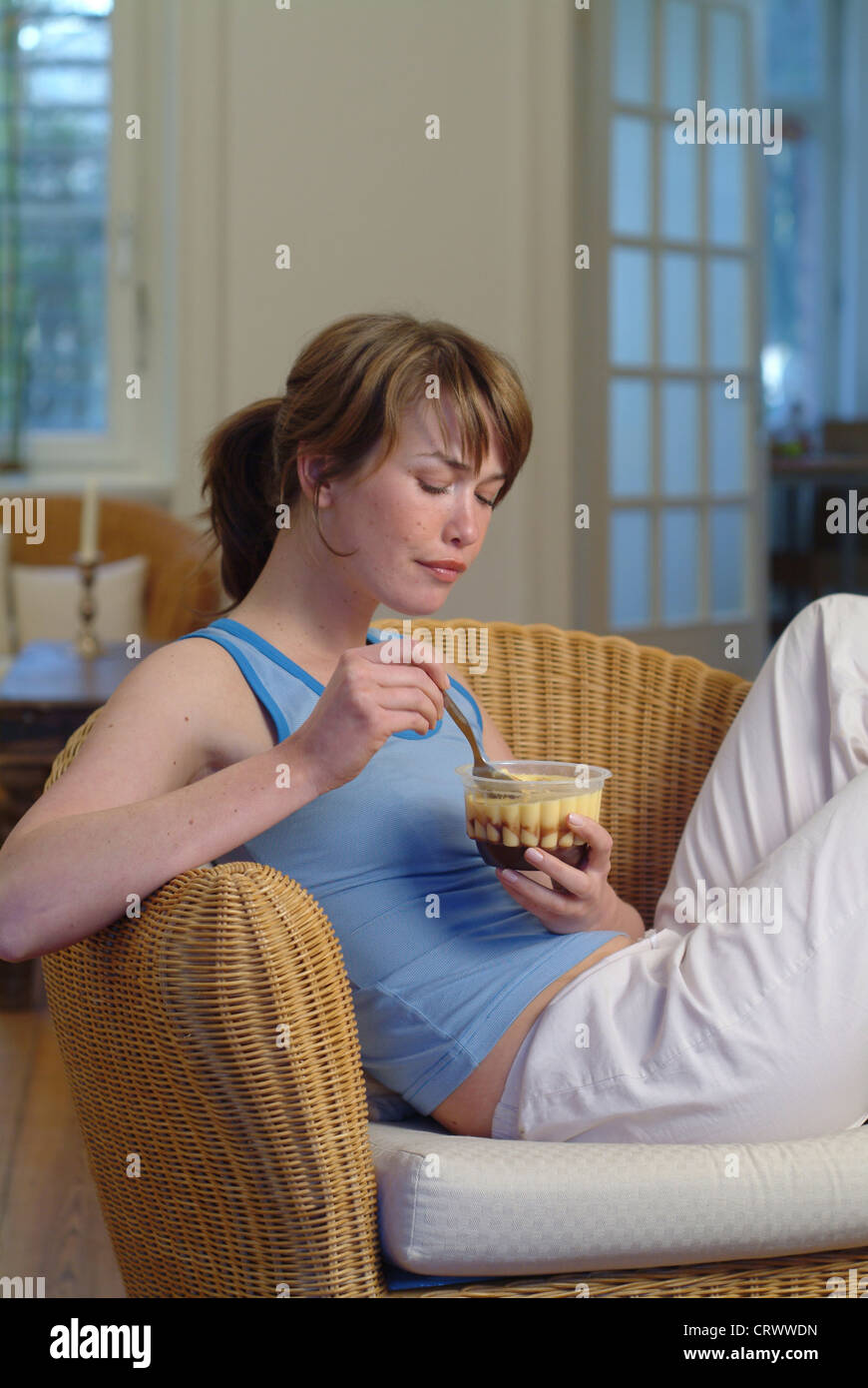 Young woman eating a pudding Stock Photo - Alamy