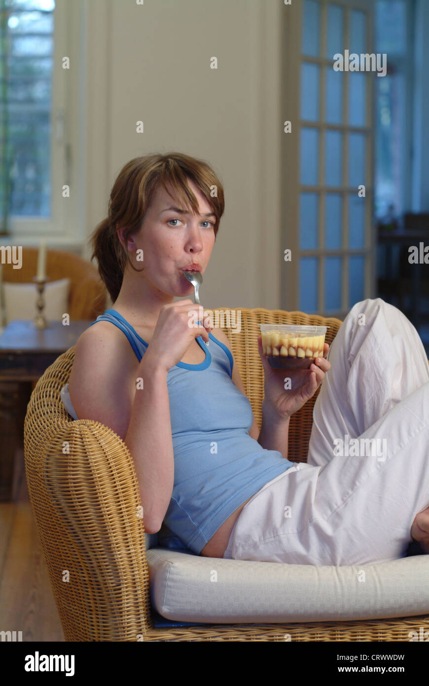 Young woman eating a pudding Stock Photo - Alamy