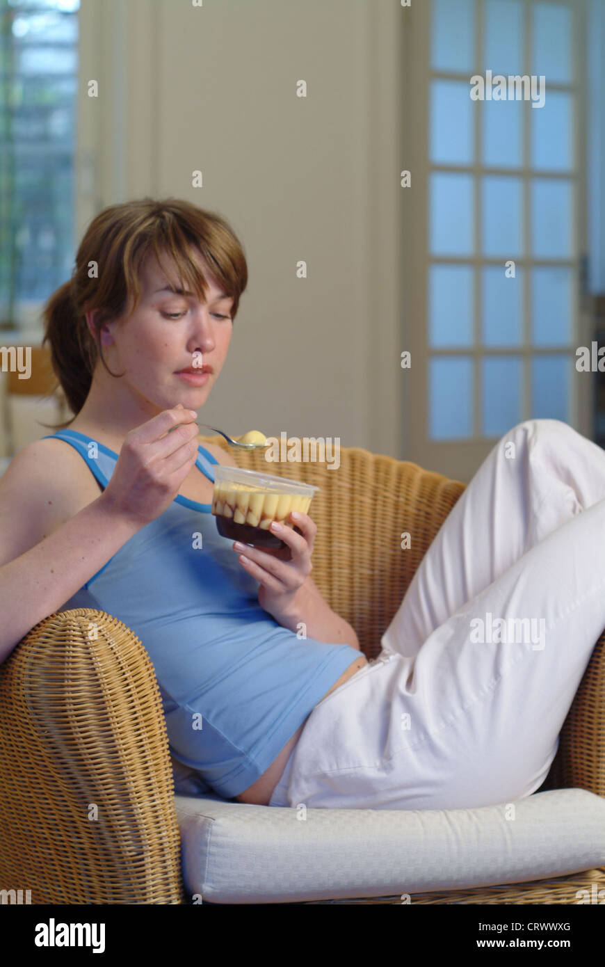 Young woman eating a pudding Stock Photo - Alamy