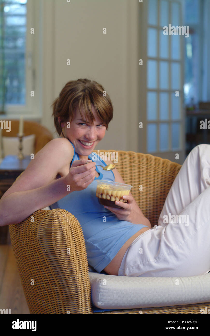 Young woman eating a pudding Stock Photo - Alamy