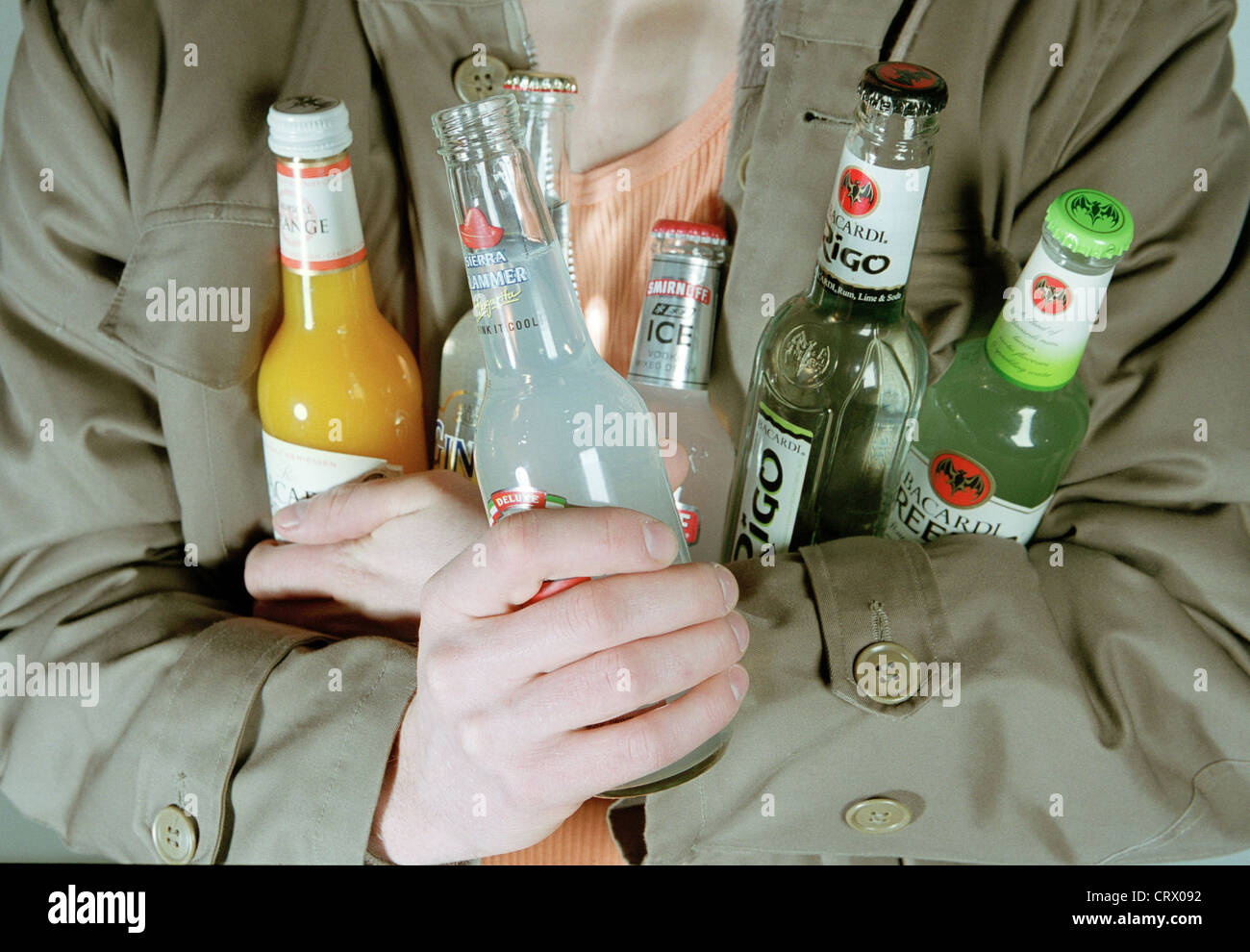 Young man holds several bottles of alcopops Stock Photo - Alamy
