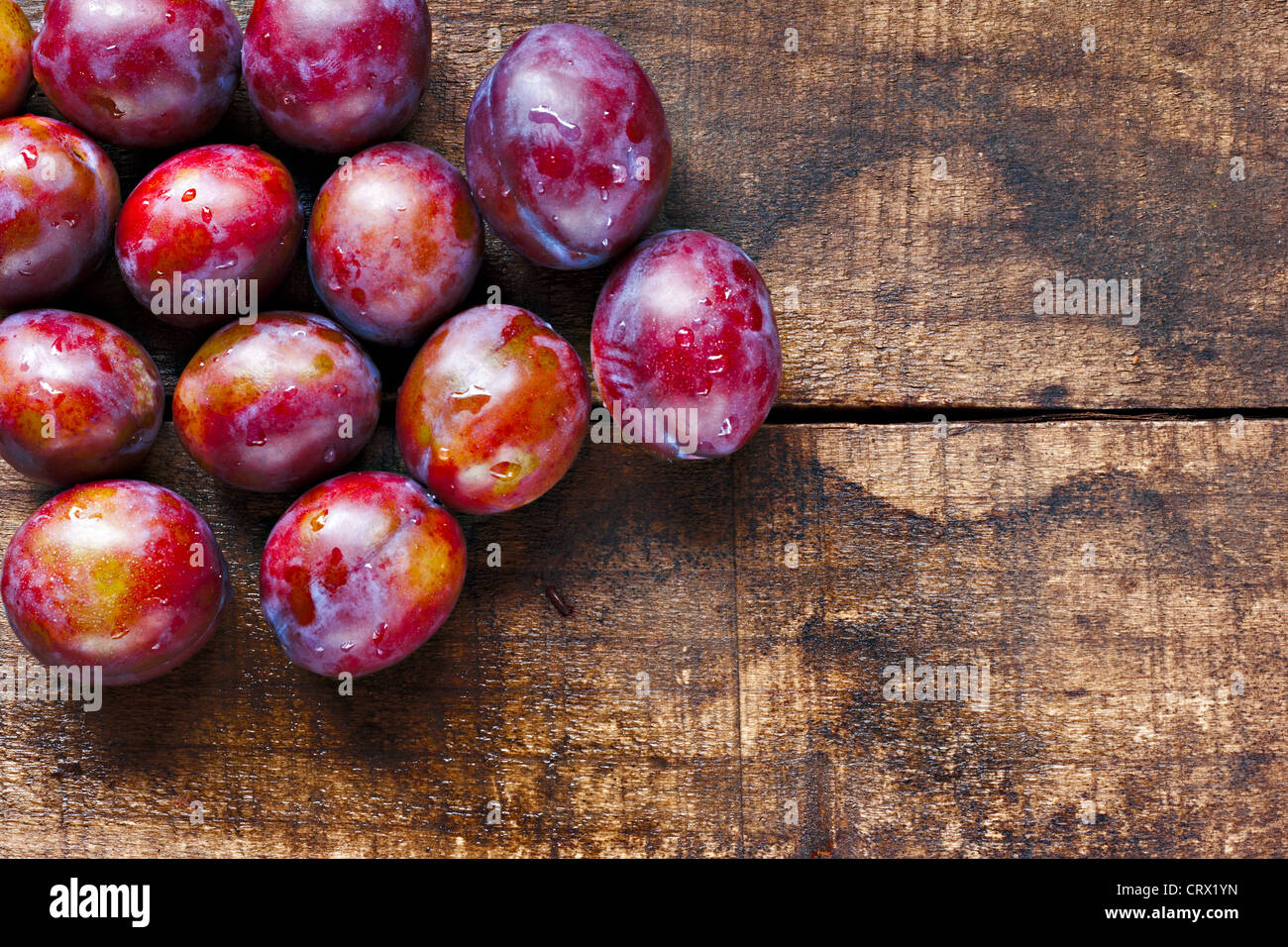 Fresh plums on old wooden table Stock Photo - Alamy