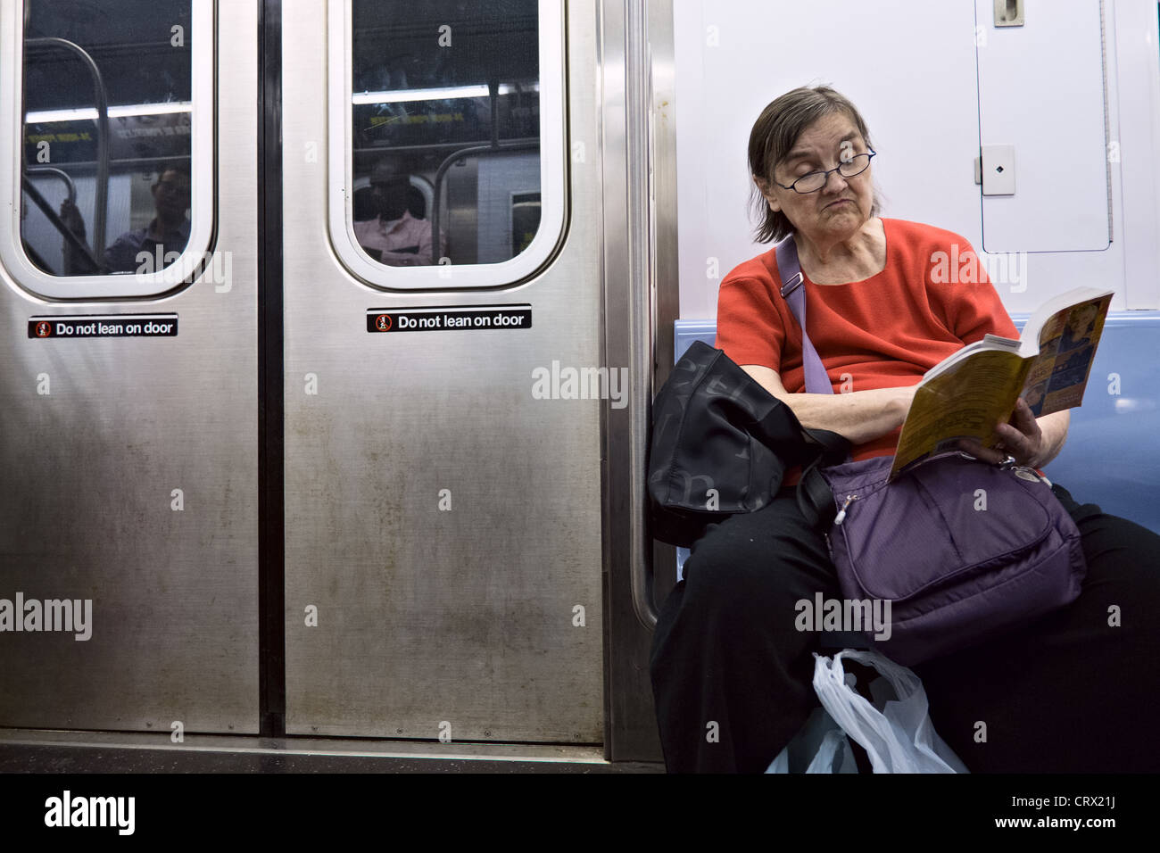 Woman reading book on subway Stock Photo - Alamy