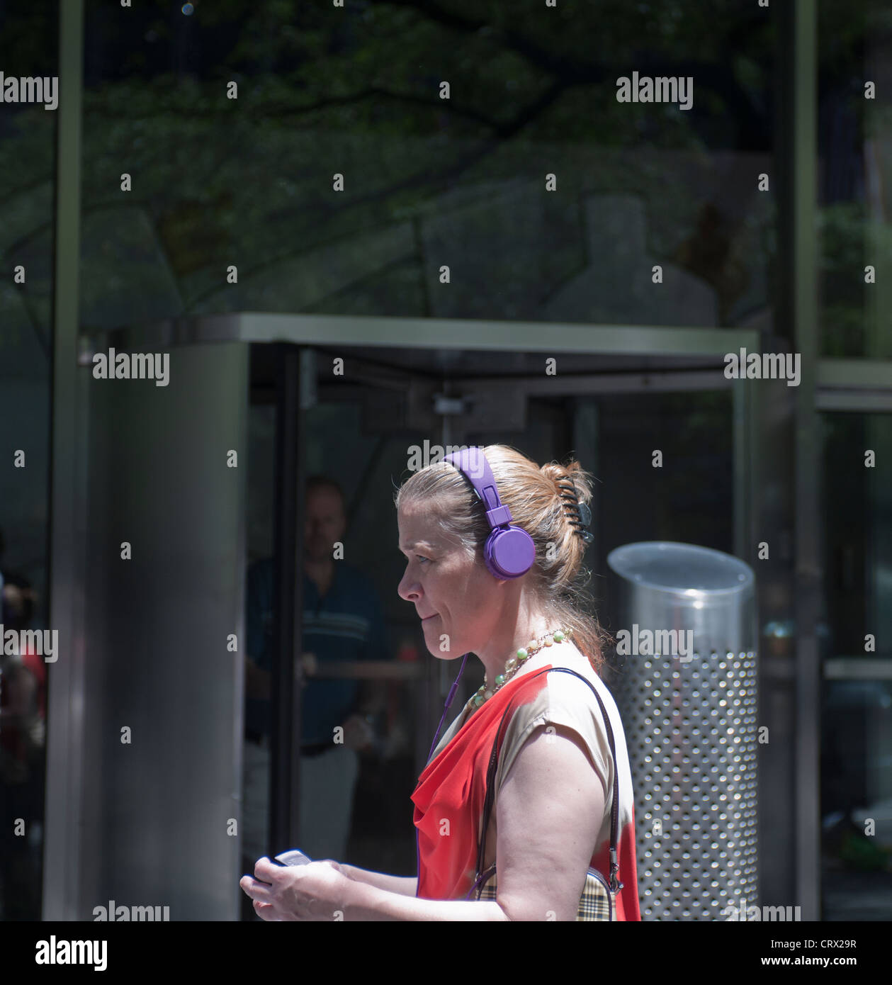 A music listener wears her over the ear headphones in New York Stock ...