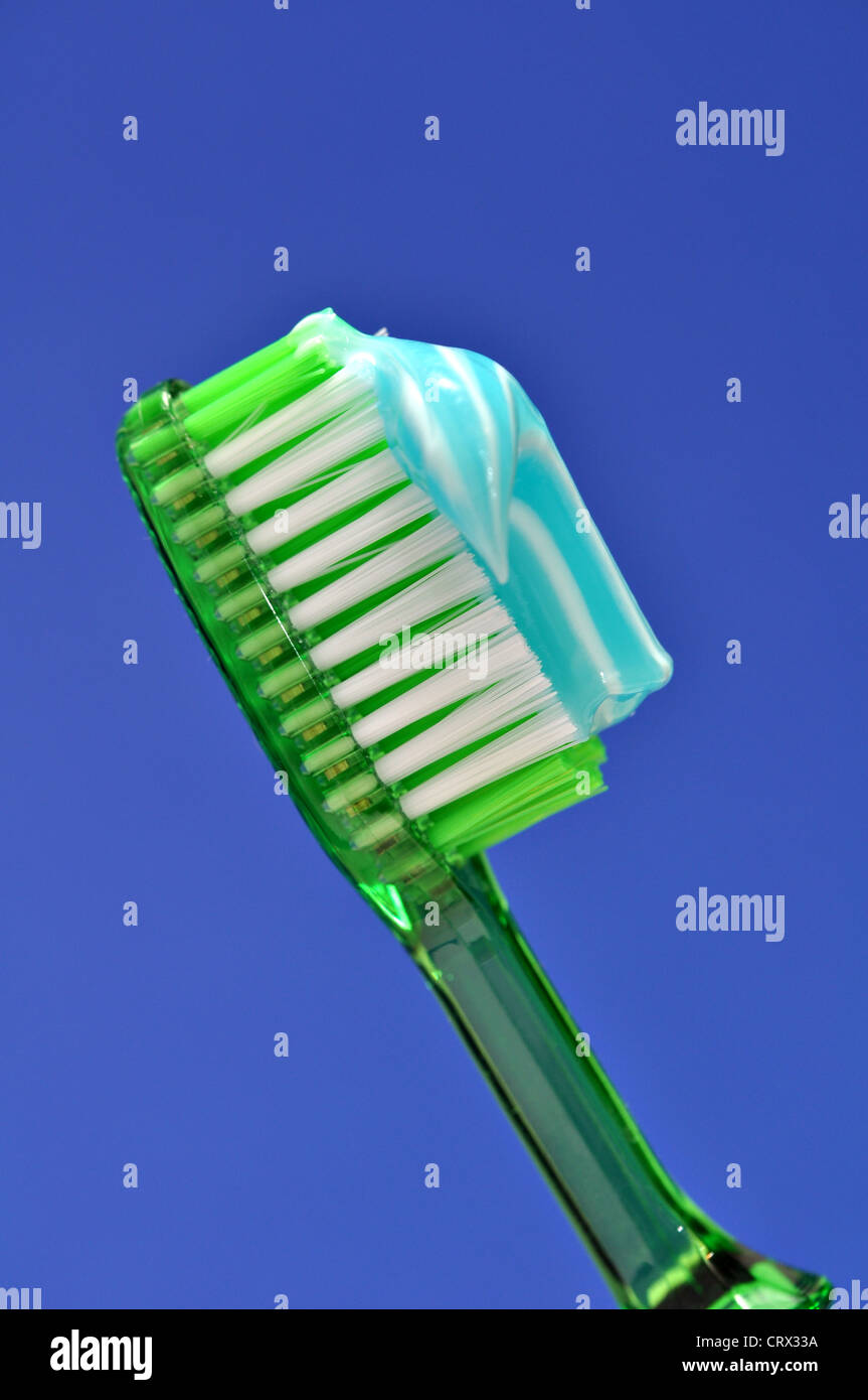 A green tooth brush with blue and white tooth paste on it Stock Photo ...