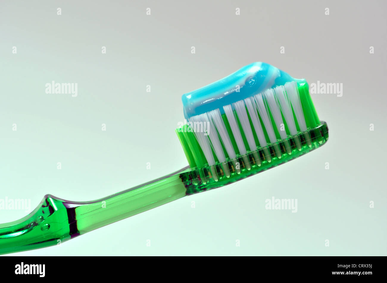 A green tooth brush with blue and white tooth paste on it Stock Photo ...