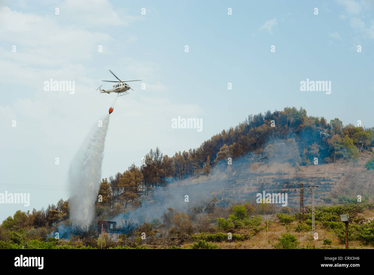 Firefighters helicopter in action, dumping water on a forest fire Stock ...