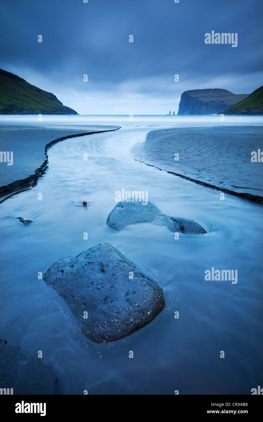 A stream runs into the sea at Tjornuvik on the island of Streymoy in ...