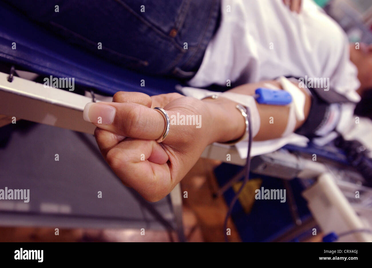 Young woman donor with an open fist as the blood flows through the ...