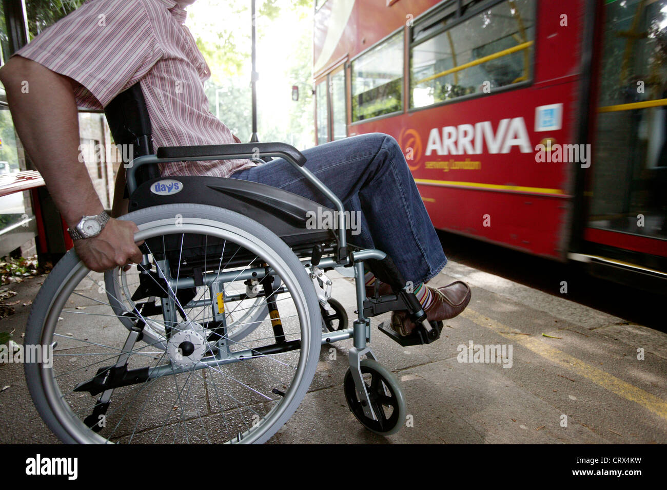 A disabled man in a wheelchair at a bus stop in London, England Stock ...