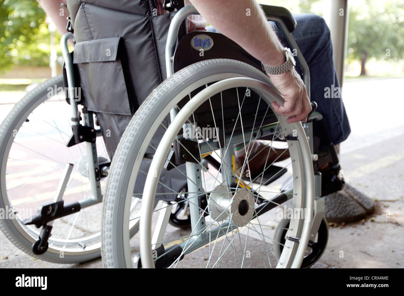 A disabled man propelling his wheelchair Stock Photo - Alamy